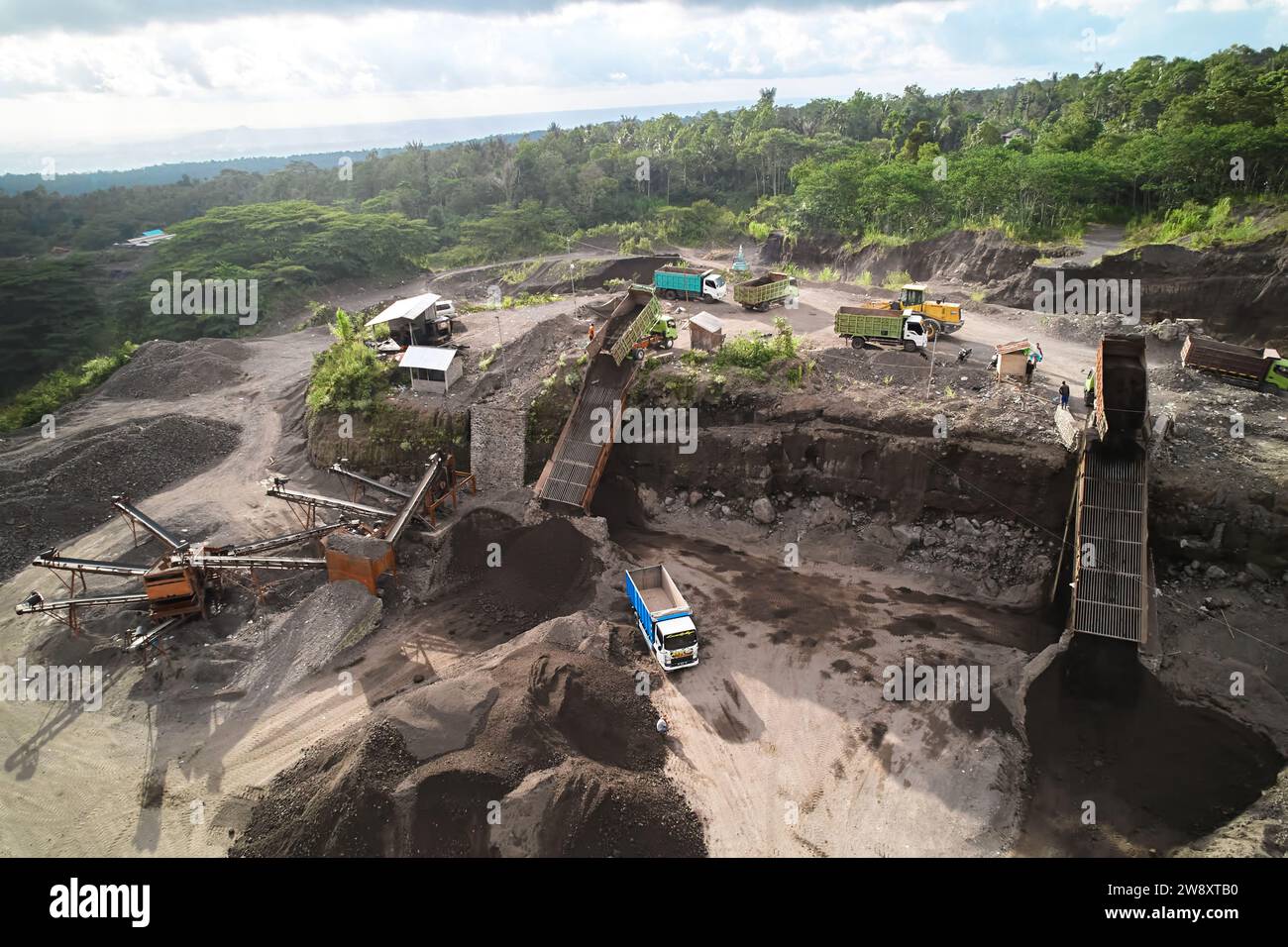 A stone quarry in Indonesia. Large equipment such as bulldozers and ...