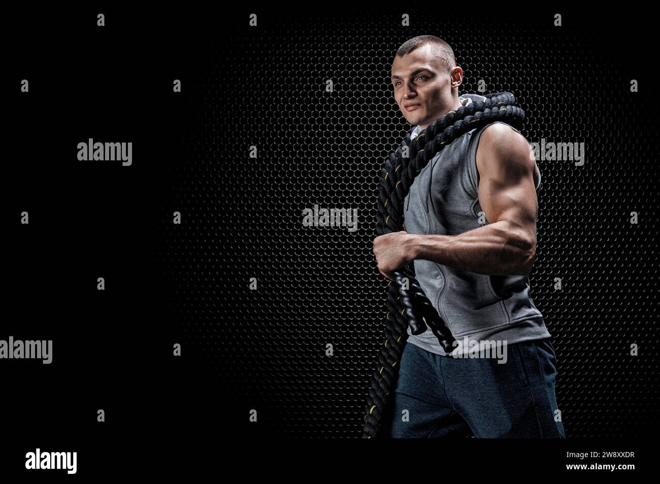 Portrait of an athlete with ropes on his shoulders. The concept of ...