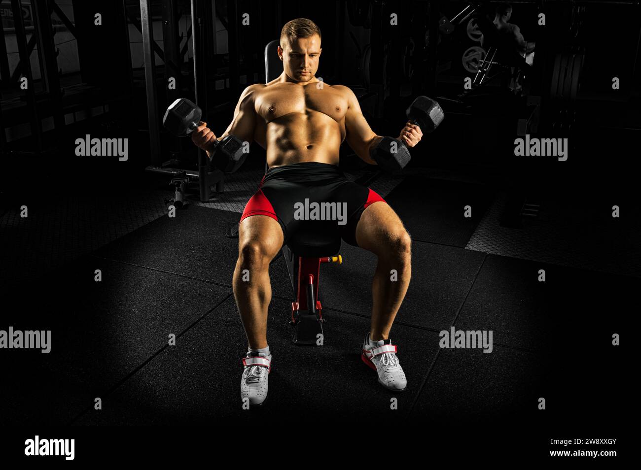 Professional athlete makes an exercise on the biceps by lifting ...