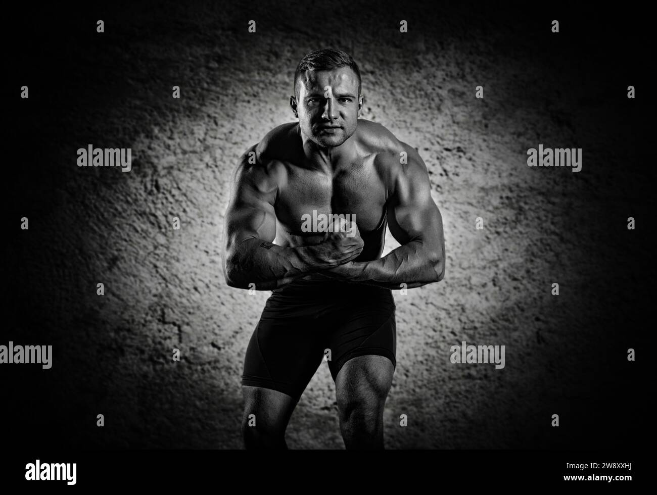 The weightlifter is posing in front of the camera, monstrously ...