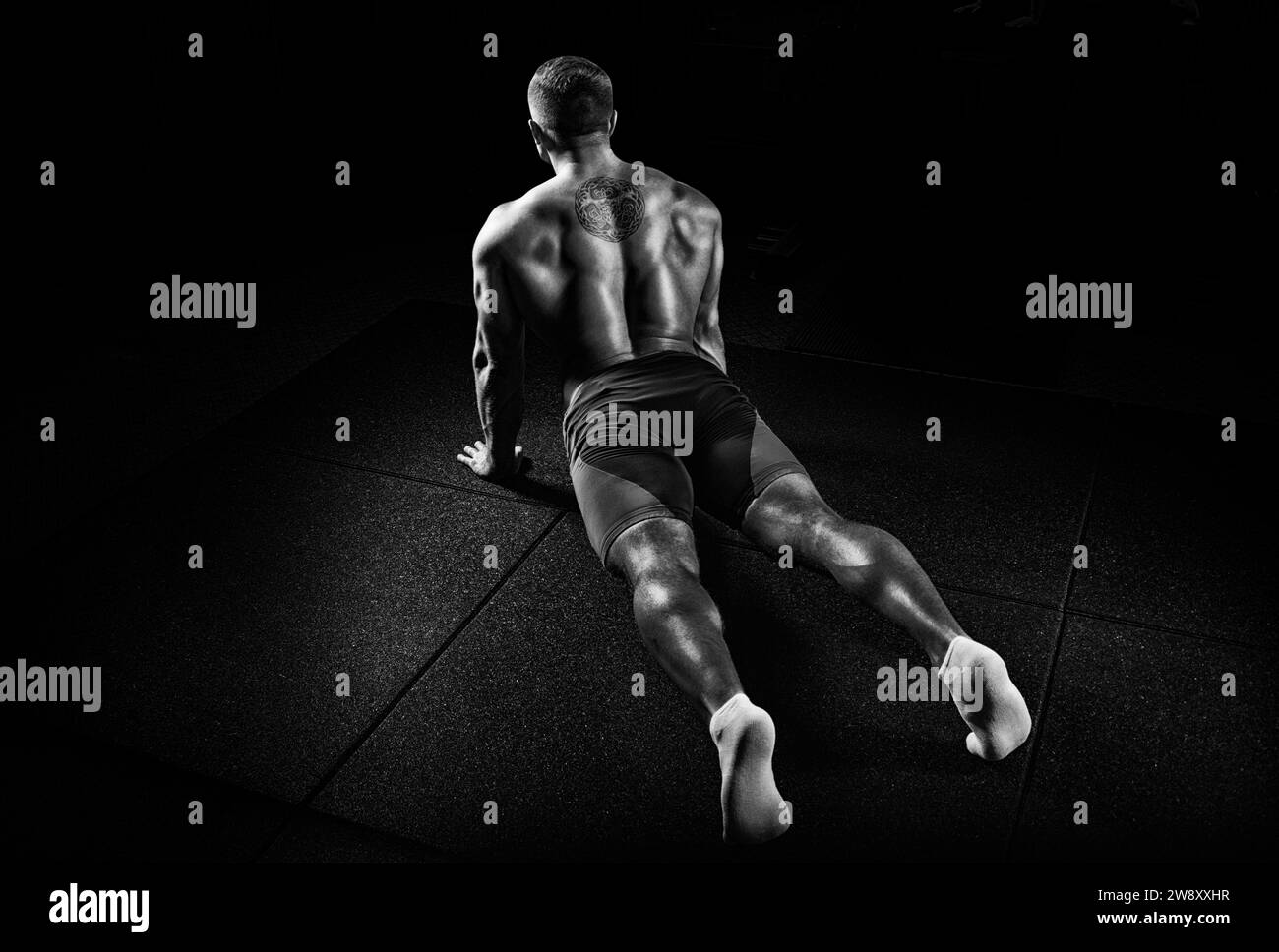 The athlete is stretched on a special cover in the gym. View from above ...