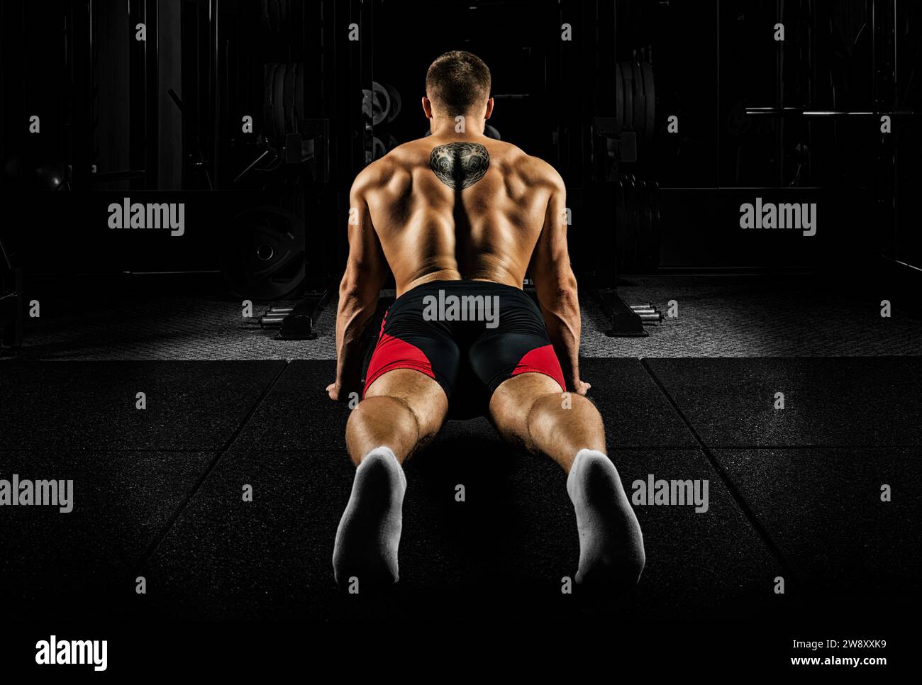 The athlete is stretched on a special cover in the gym. Back view Stock ...