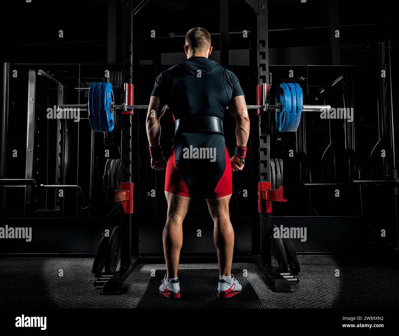 Professional athlete stands in front of the bars with a barbell and is ...