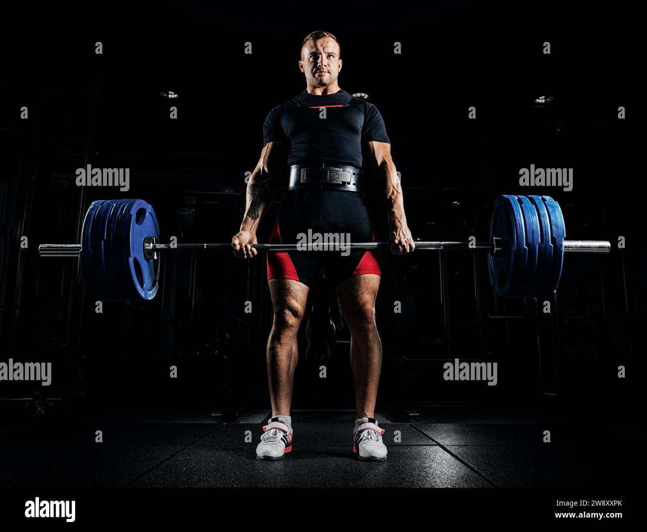 Professional athlete is standing and is holding a very heavy barbell ...