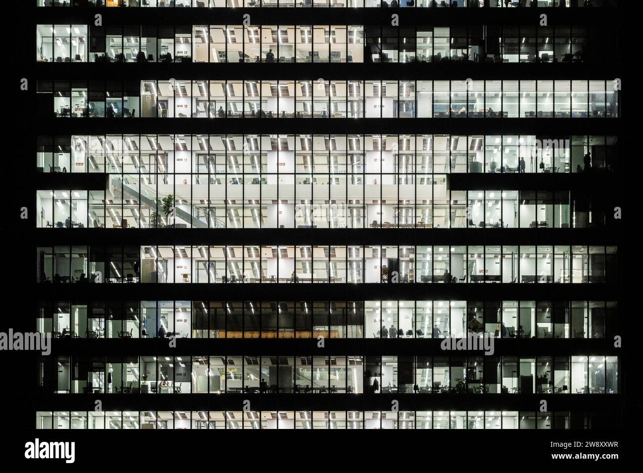 Series of offices at night in a modern building seen from the outside ...