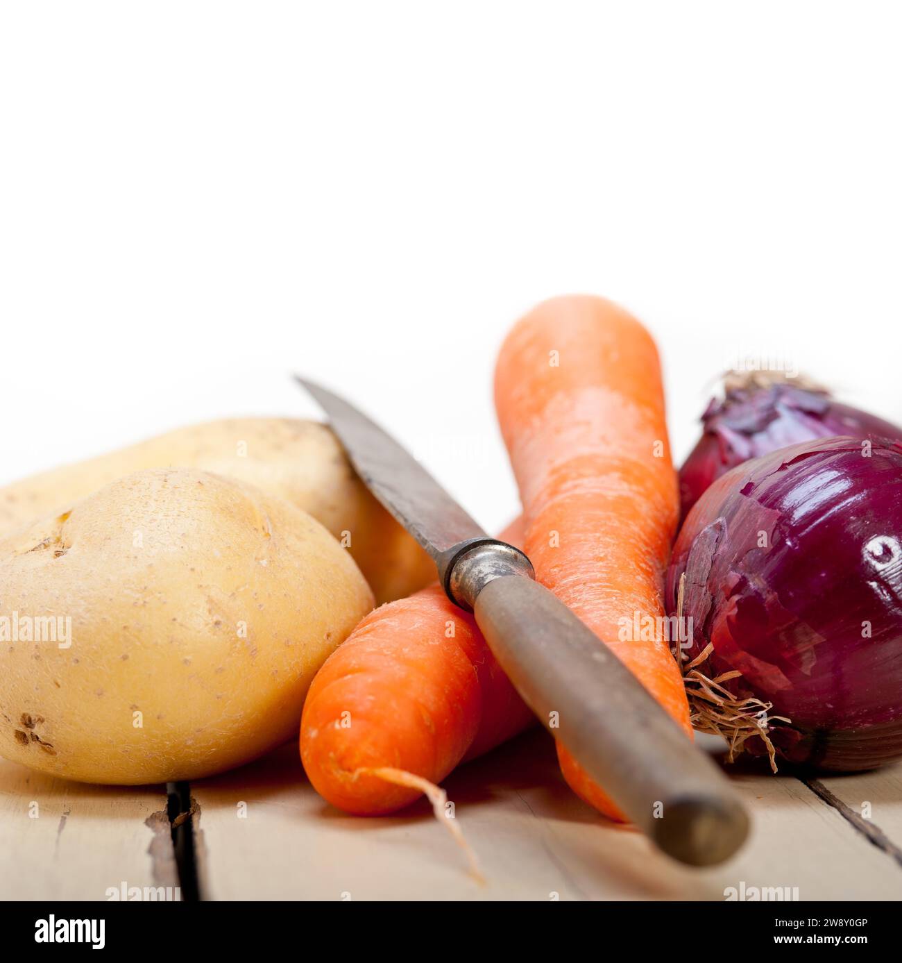 Basic vegetable ingredients carrot potato onion on a rustic wood table ...