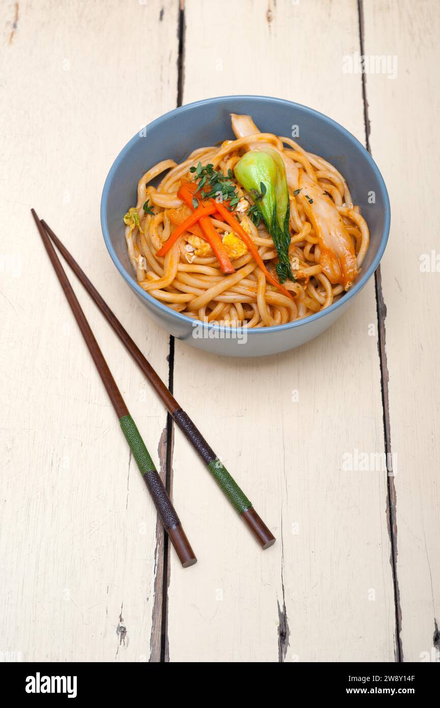 Hand pulled stretched Chinese ramen noodles on a bowl with chopstick ...
