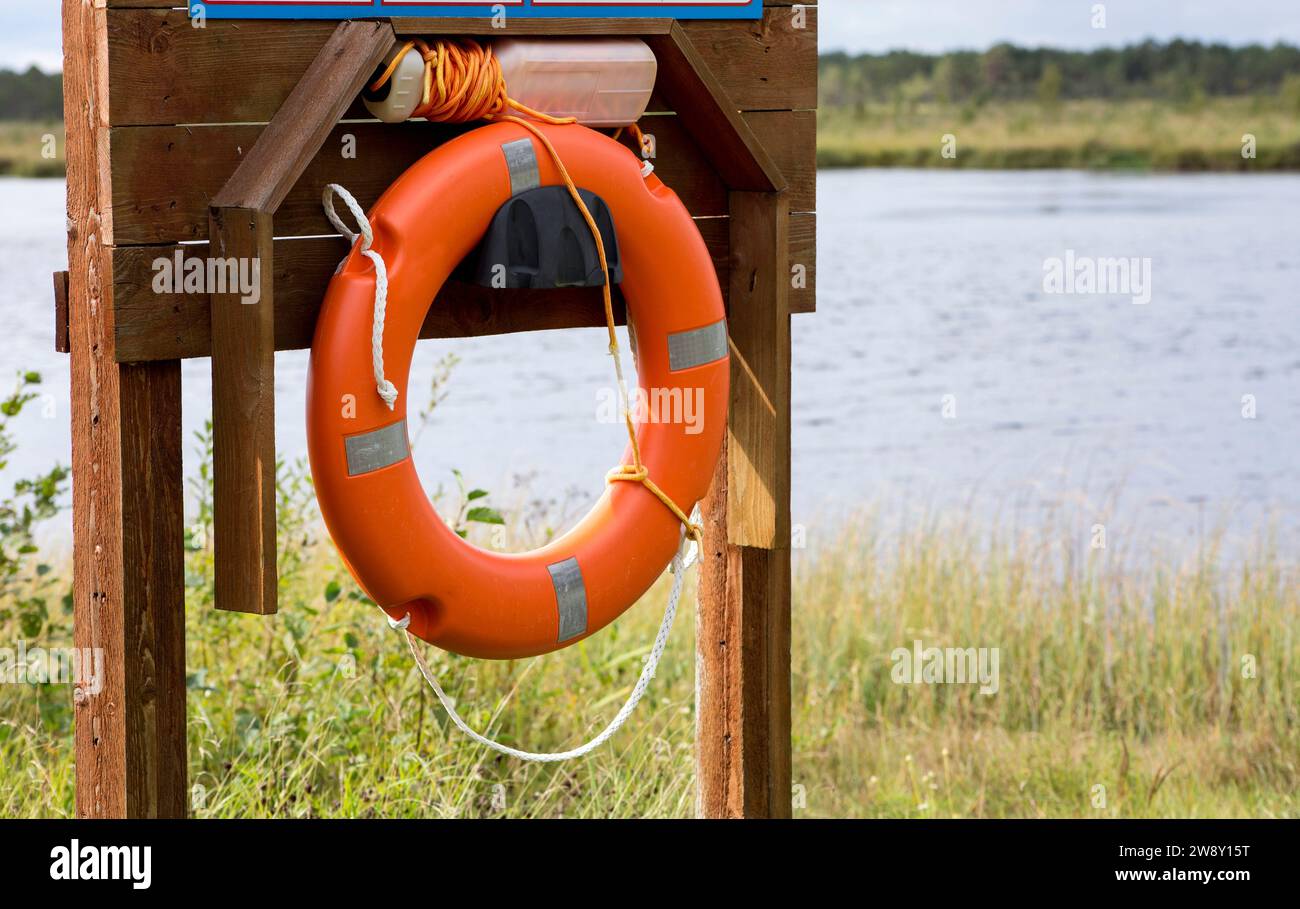 Orange color round self help lifebuoy by small local swimming spot by ...