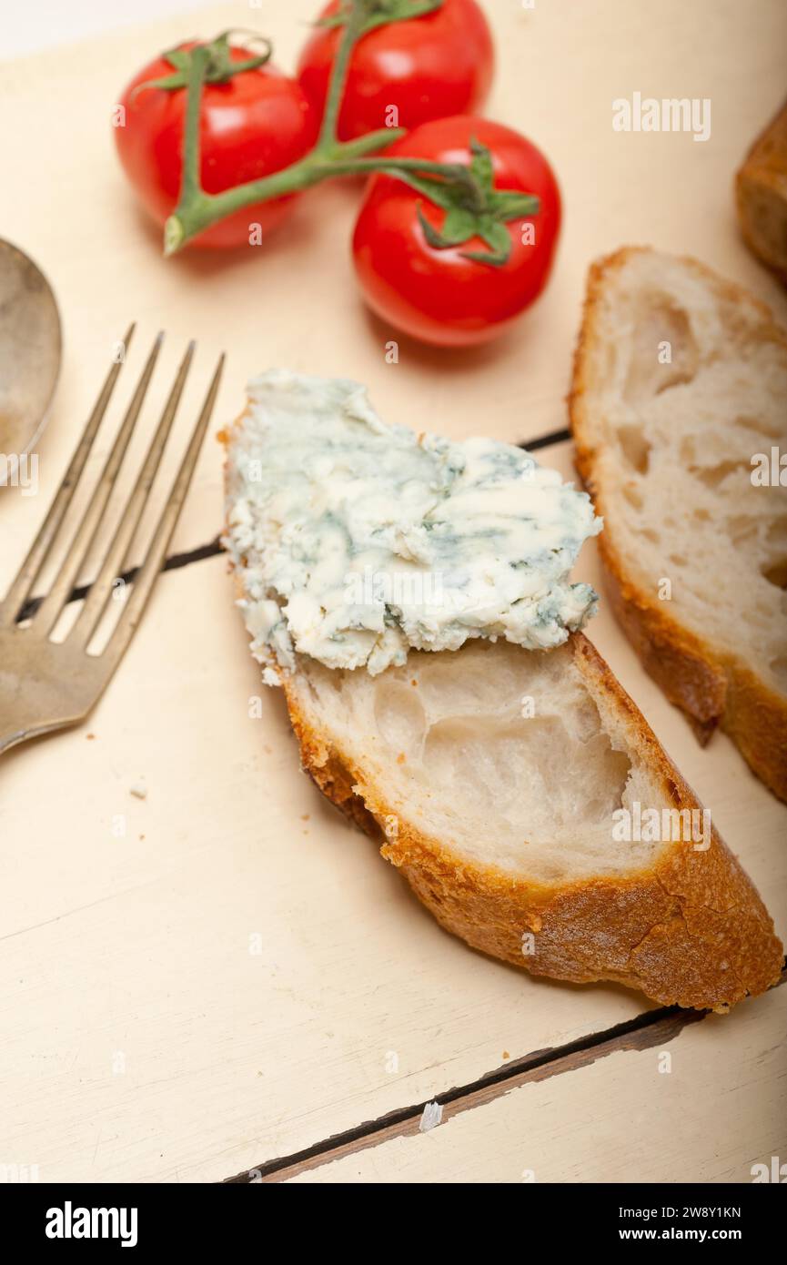 Fresh blue cheese spread ove french baguette with cherry tomatoes on ...