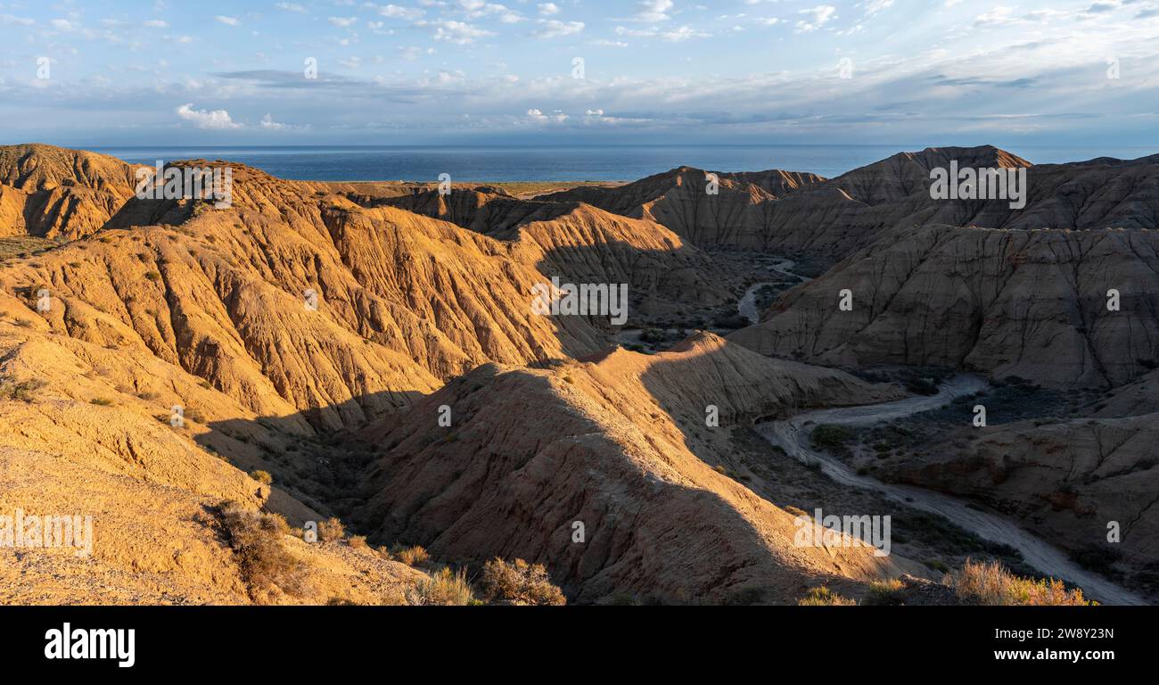 Canyon runs through a landscape of eroded hills at sunrise, Badlands ...