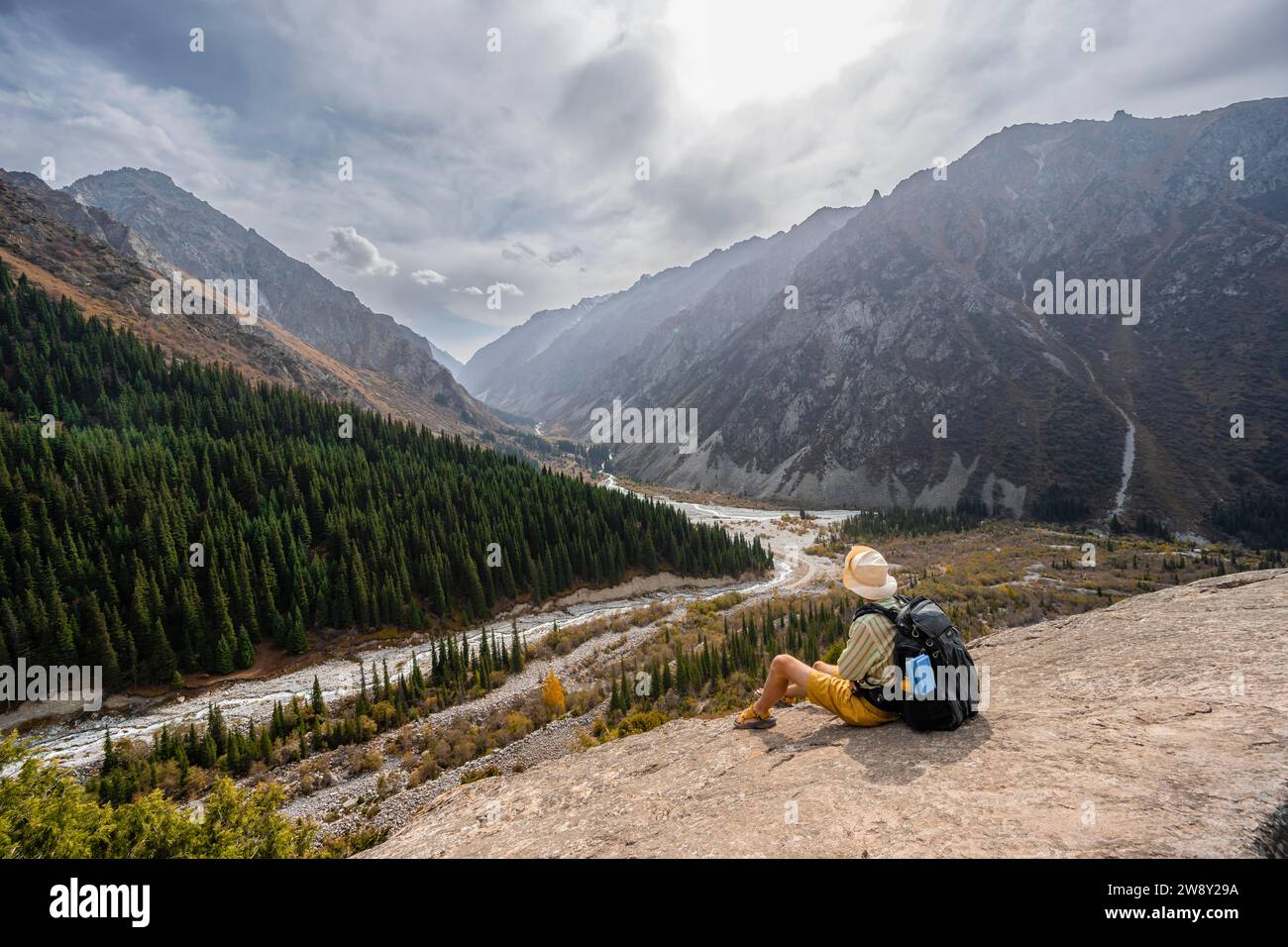 View of the Ala Archa valley from the viewpoint, hiker on a large rock ...
