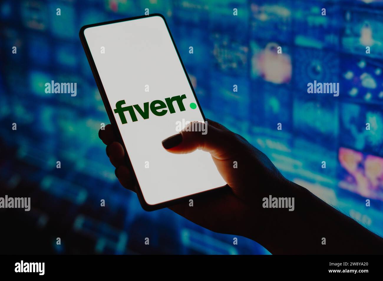 In this photo illustration, the Fiverr logo is displayed on a ...