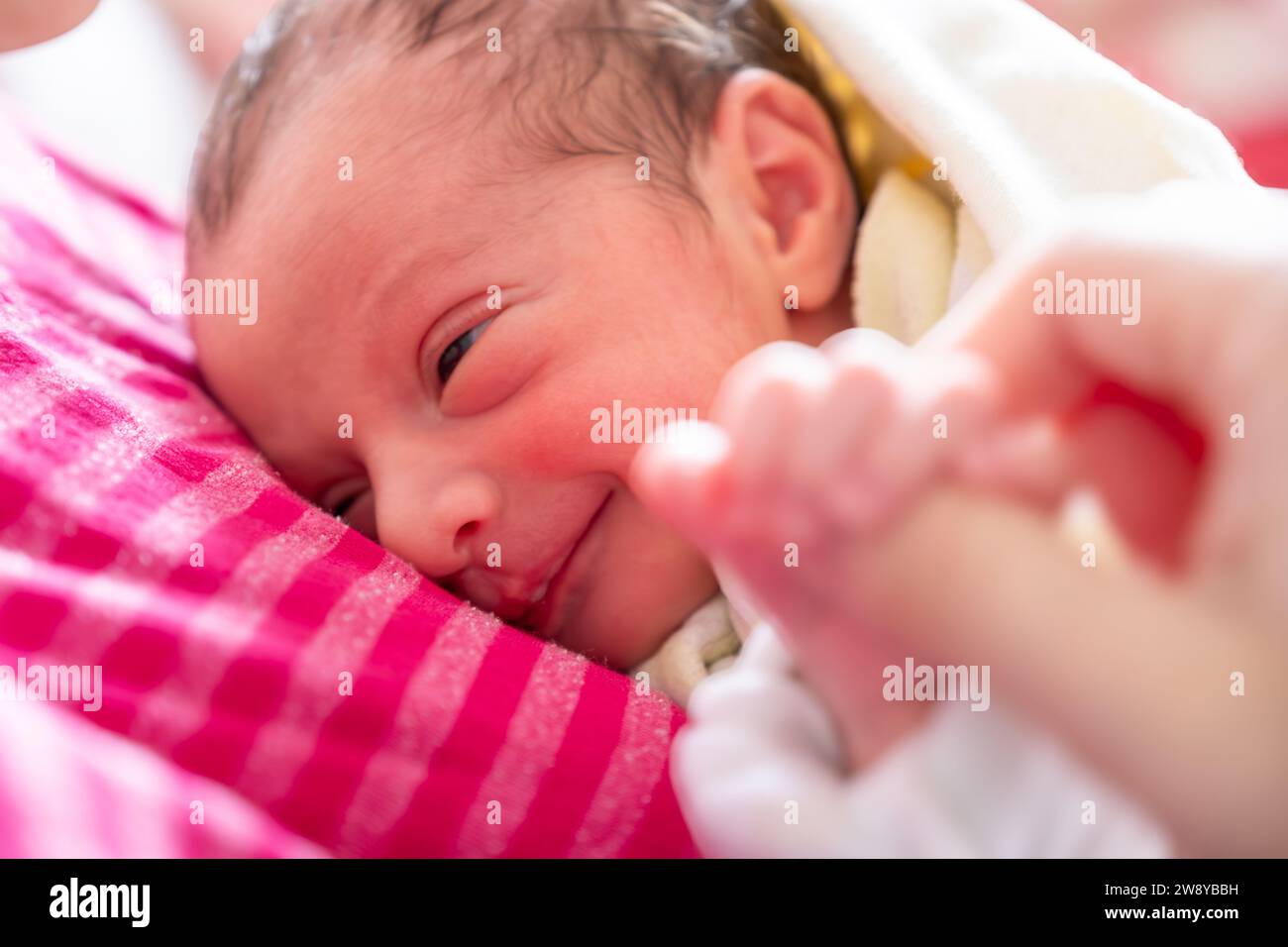 mother cuddling her newborn with smile on their faces and adorable look ...