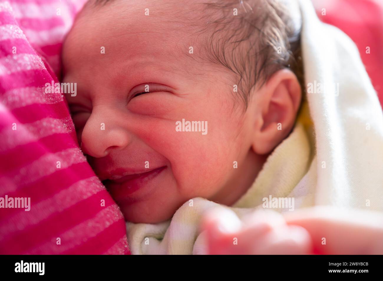 mother cuddling her newborn with smile on their faces and adorable look ...