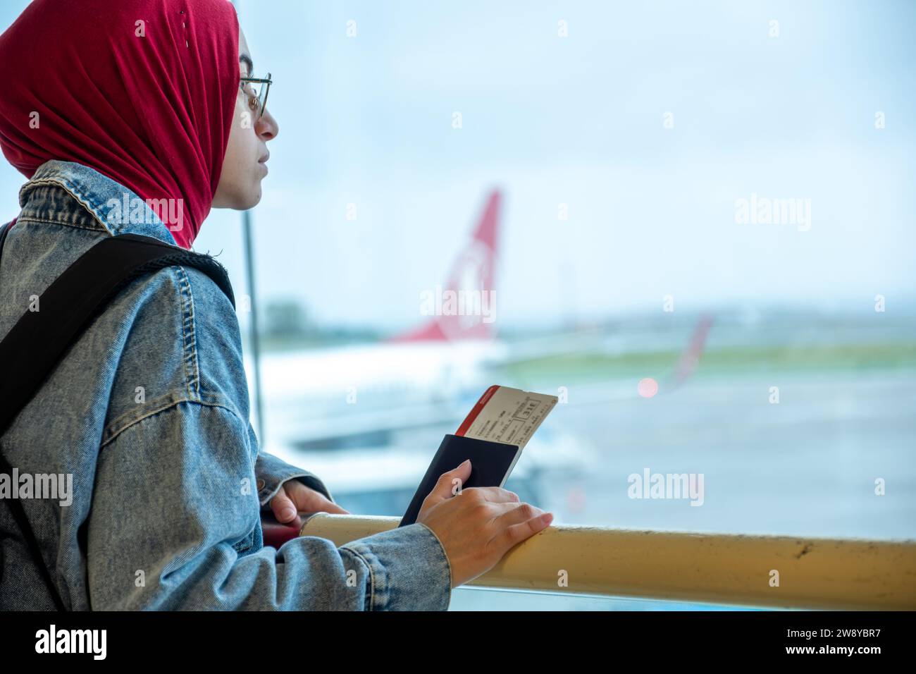 Arabic muslim female at the airport holding her passport and looking at ...