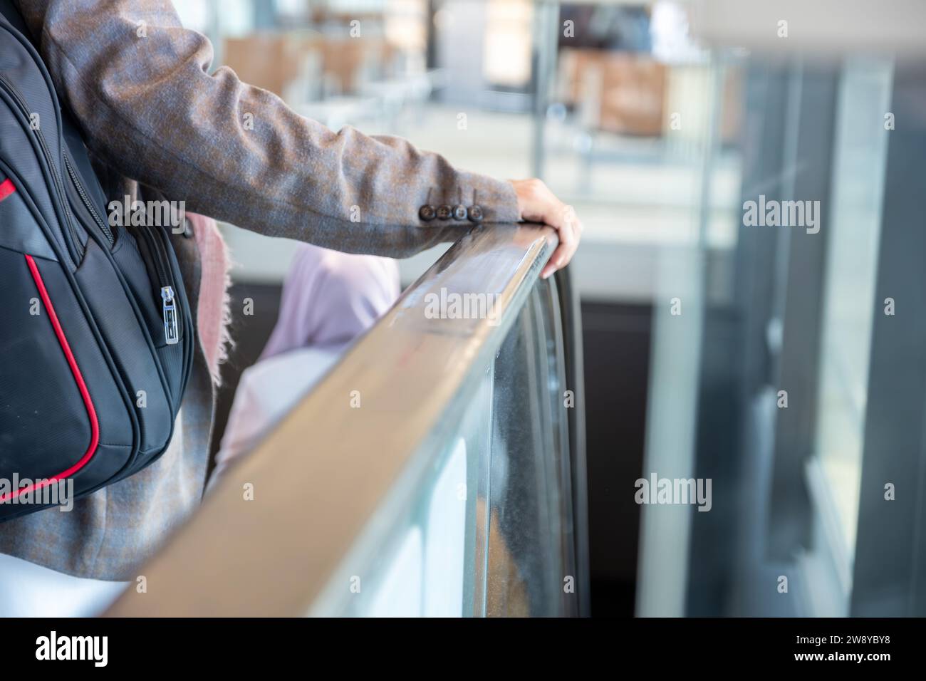 male hand on escalator handle while holding his bag inside airport ...
