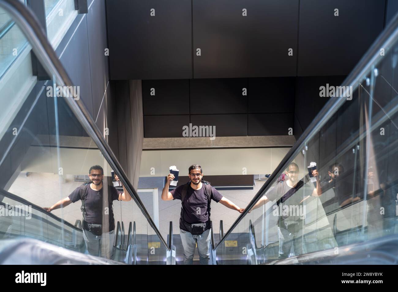 Cheerful male holding his passport after long journey feeling excited ...