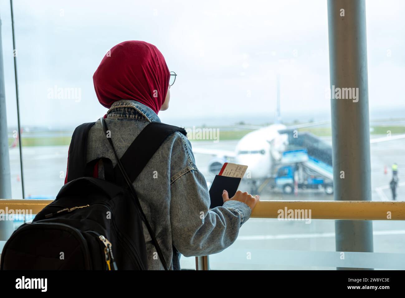 Arabic muslim female at the airport holding her passport and looking at ...