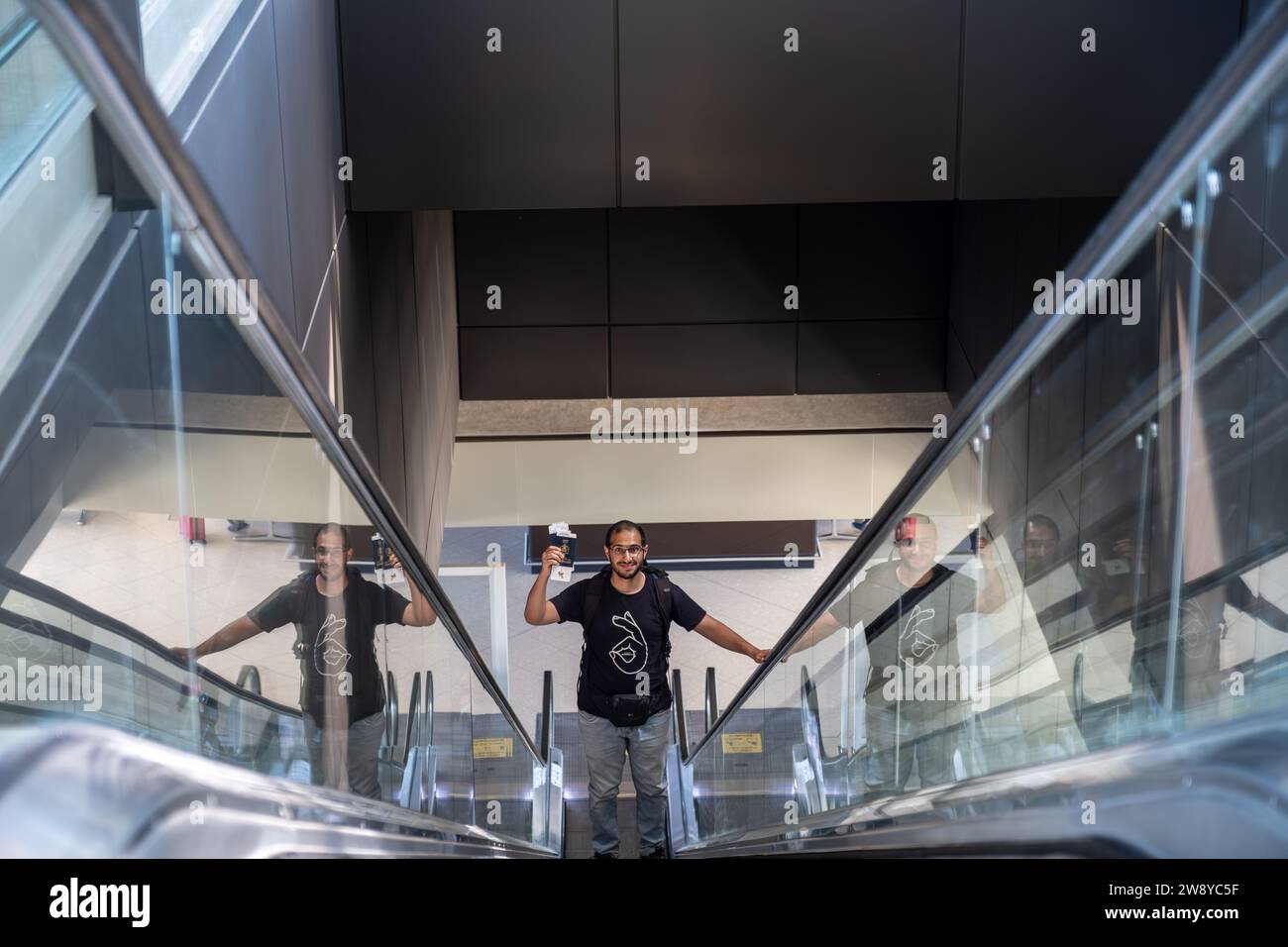 Cheerful male holding his passport after long journey feeling excited ...