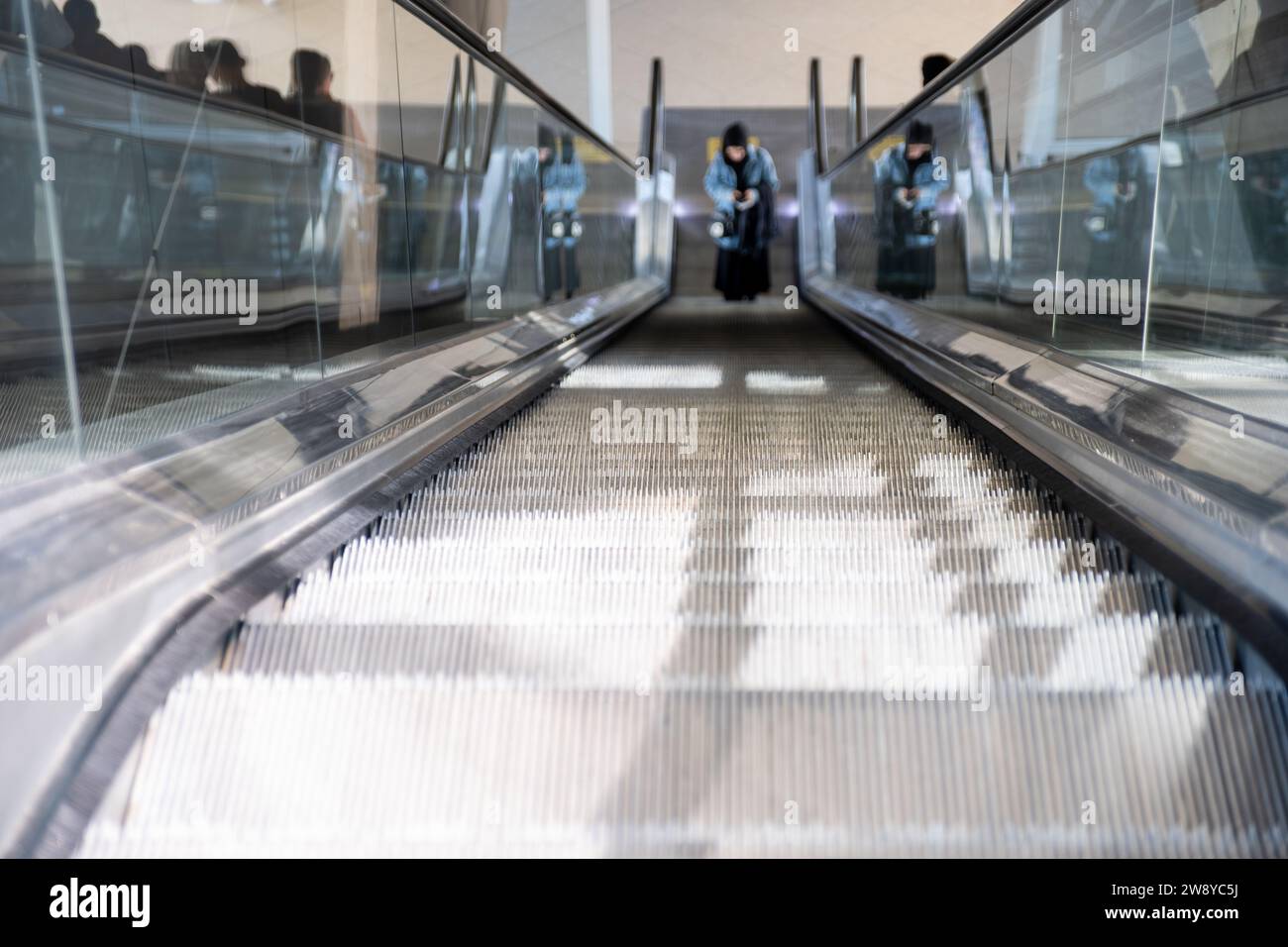 Female using escalator to go up to next floor Stock Photo - Alamy