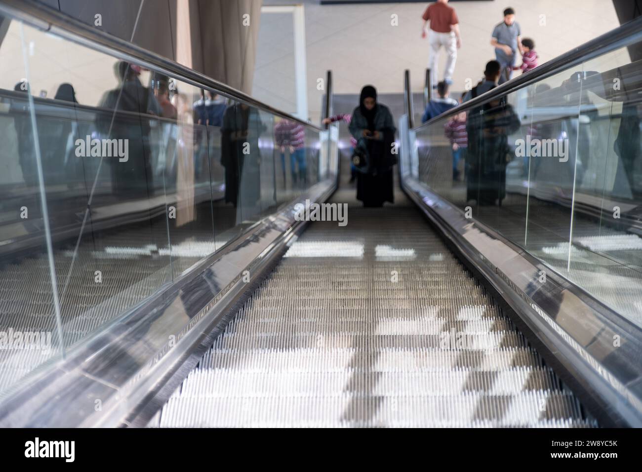 Female using escalator to go up to next floor Stock Photo - Alamy