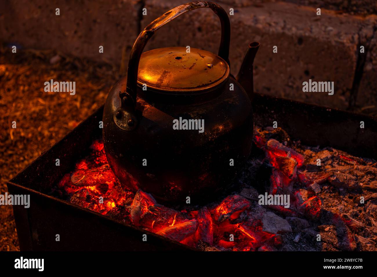 burning coals to boil water during camping and metal stove on picnic ...