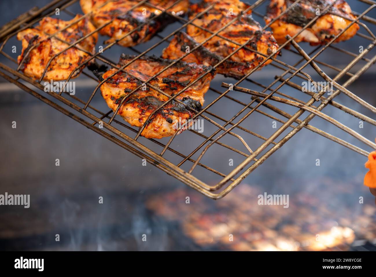 Roasted chickens on spit grilled over fire flame Stock Photo - Alamy