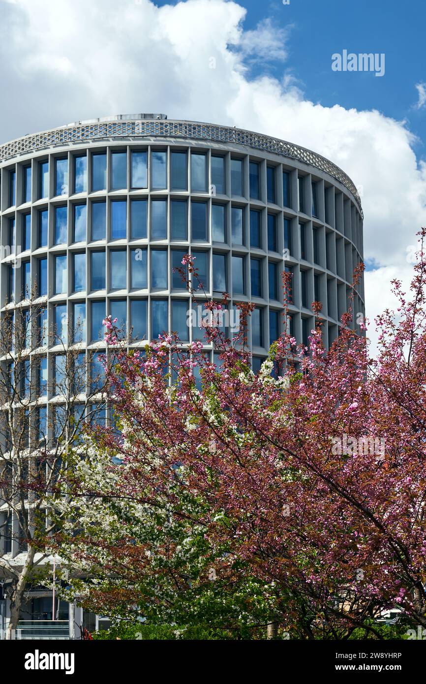 historic, modernist building in the shape of a cylinder and a flowering ...