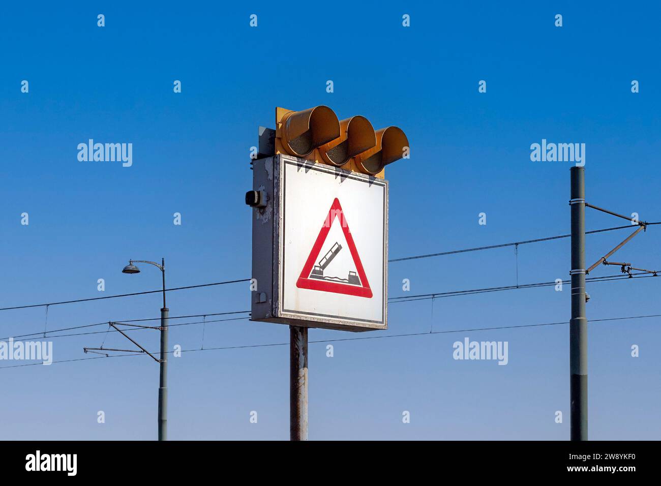 Draw bridge traffic sign symbol on a pole with blue sky in background ...