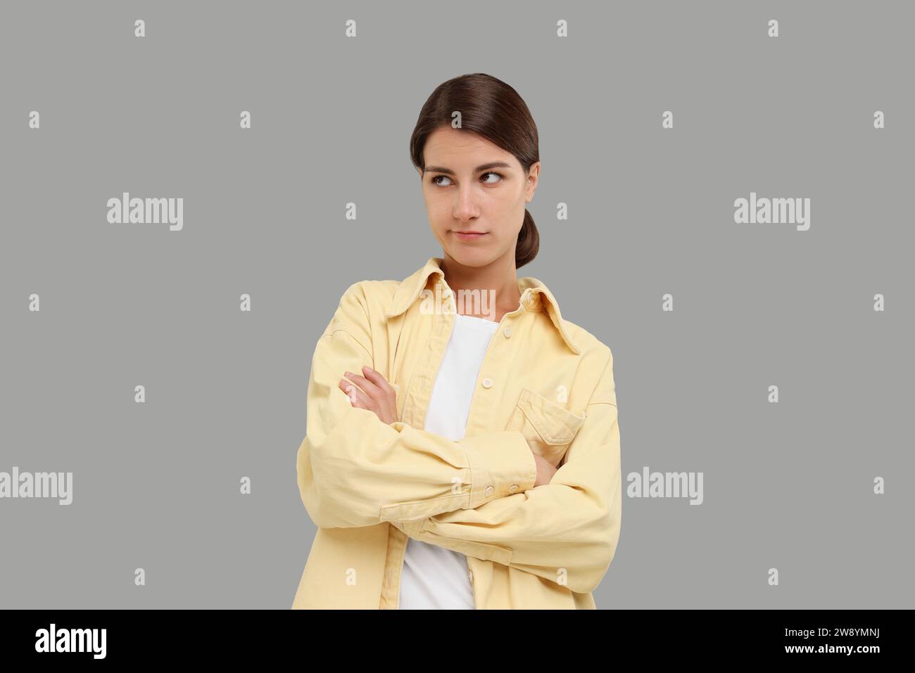 Resentful woman with crossed arms on grey background Stock Photo - Alamy