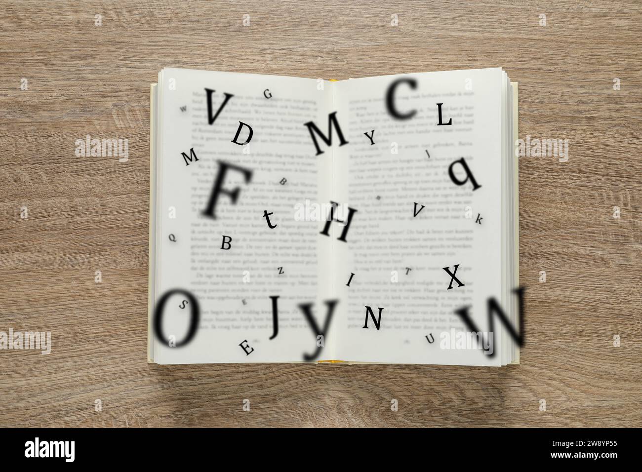 Open book with letters flying out of it on wooden background, top view Stock Photo - Alamy