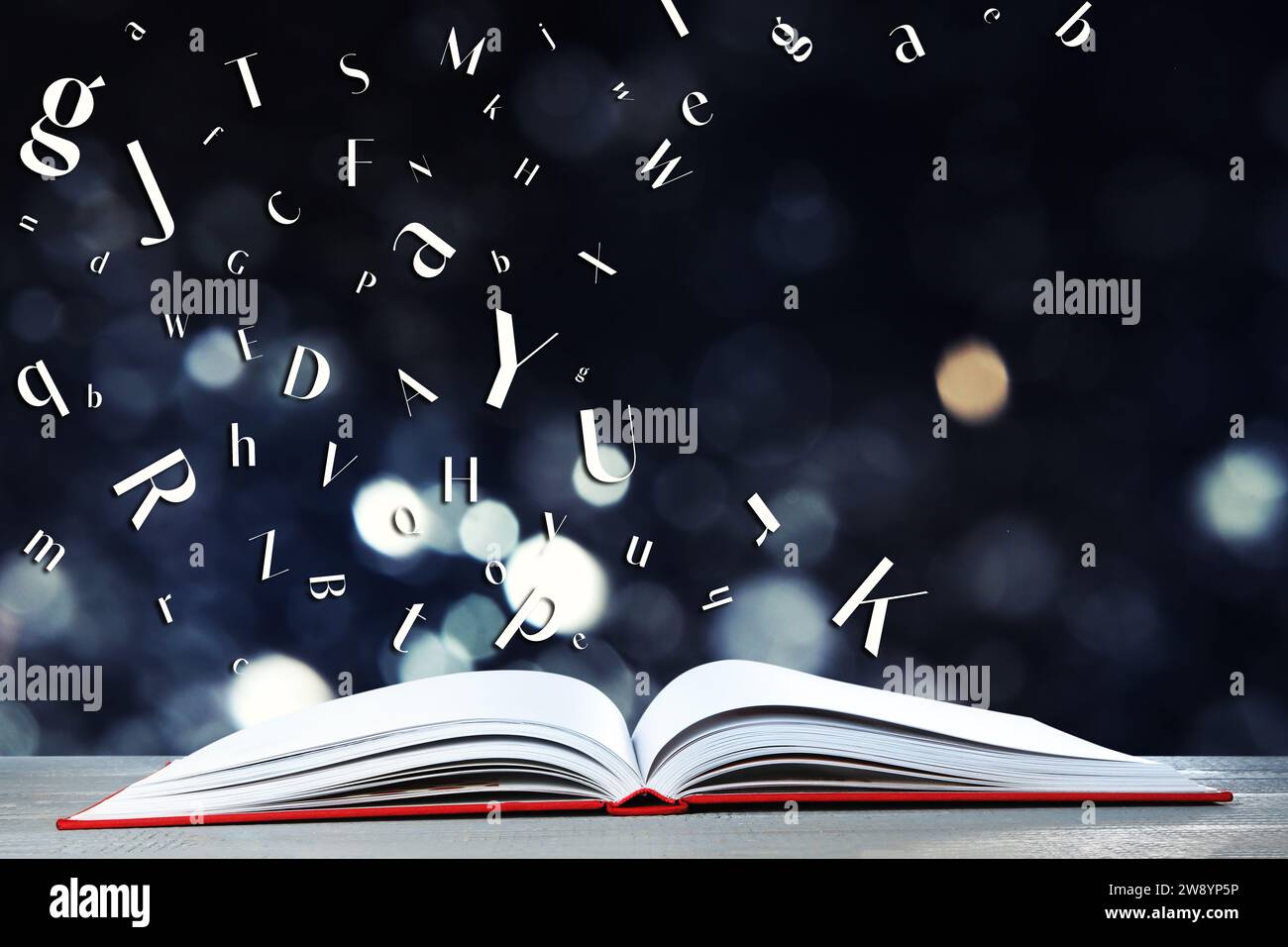 Letters flying out from open book on wooden table, bokeh effect Stock ...