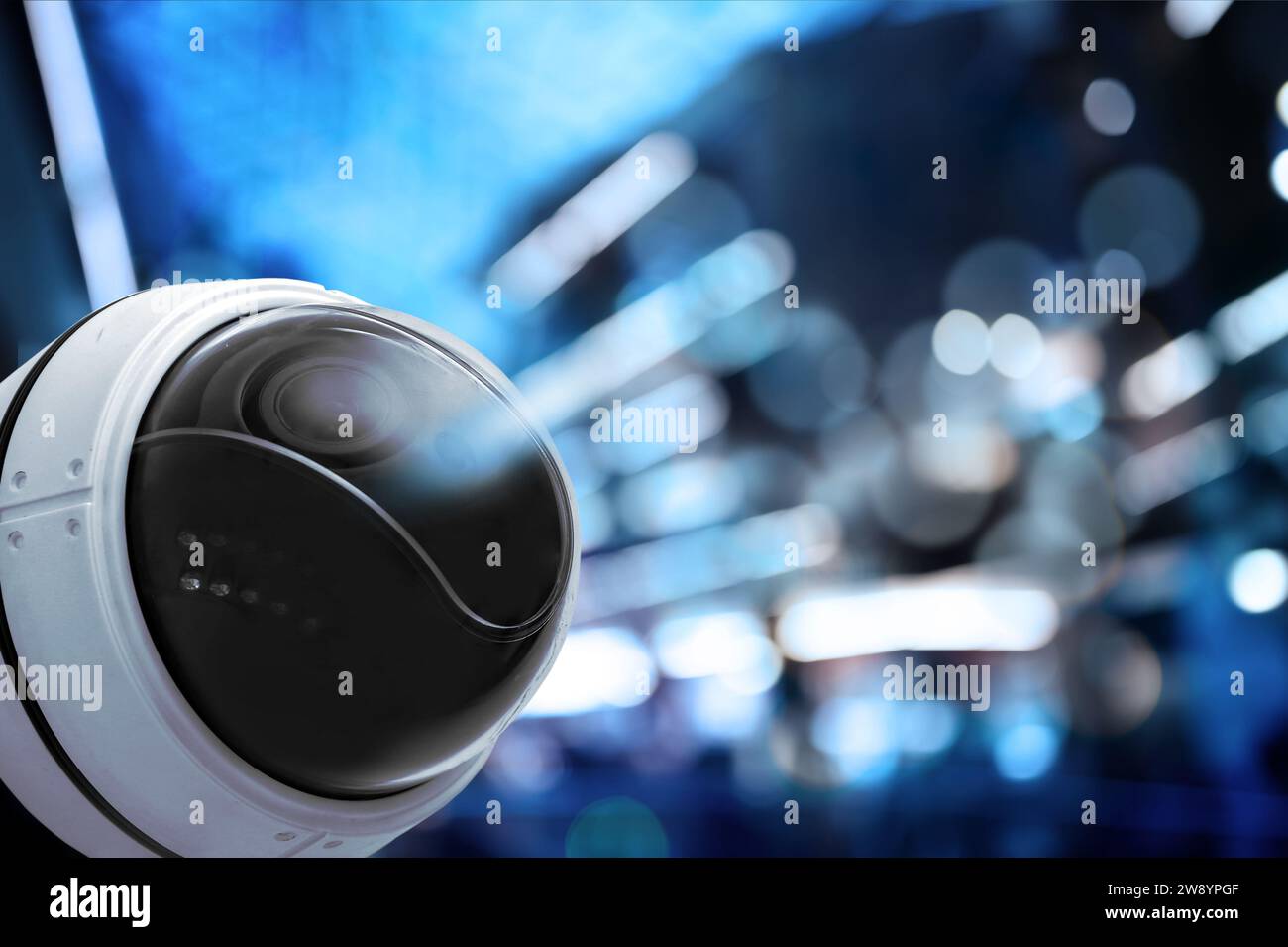Modern security CCTV camera against blurred background, space for text ...