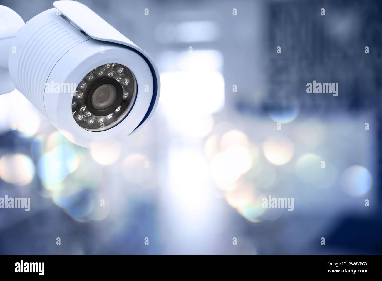 Modern security CCTV camera against blurred background, space for text ...