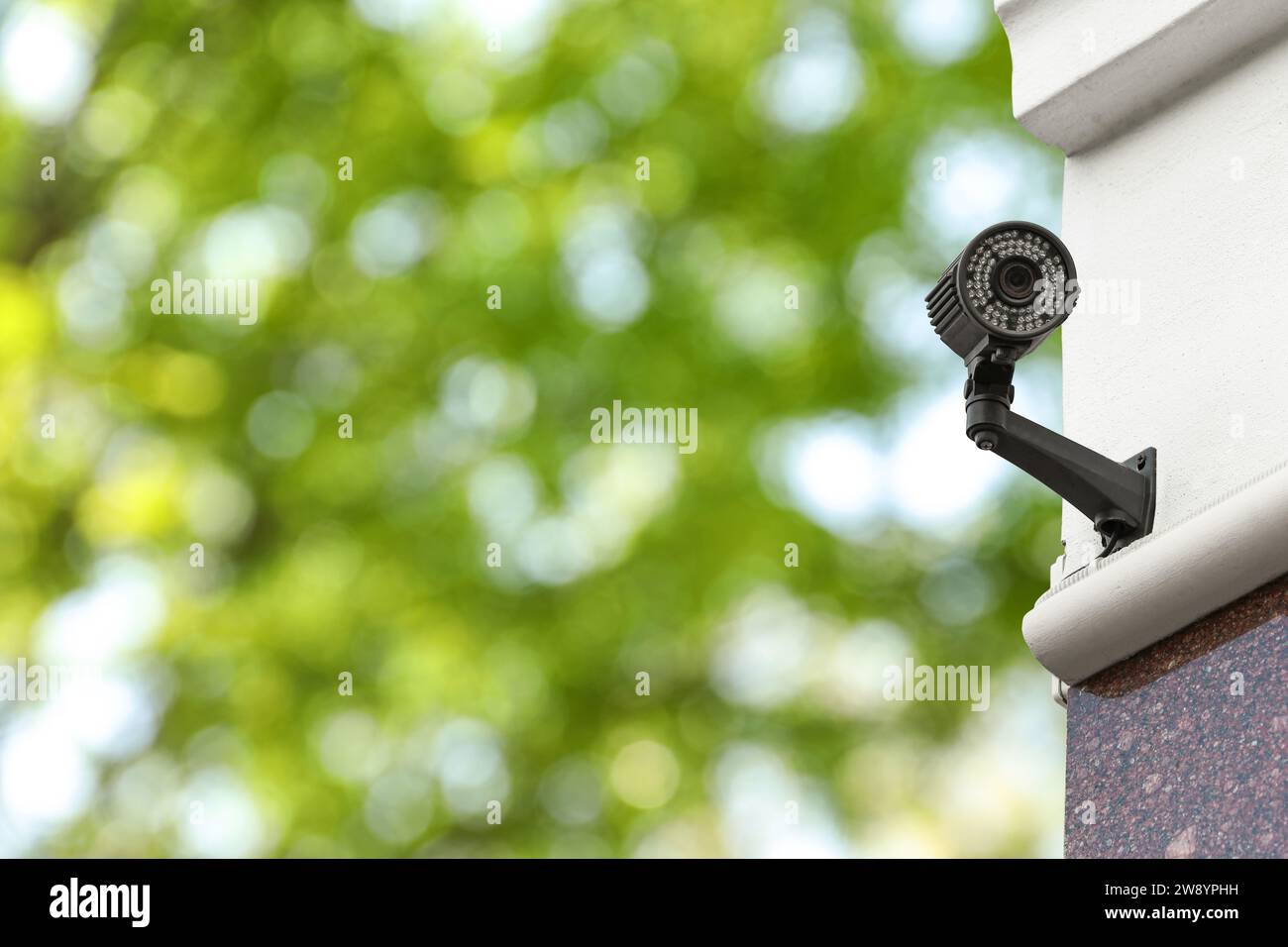 Modern security CCTV camera on building wall outdoors, space for text ...