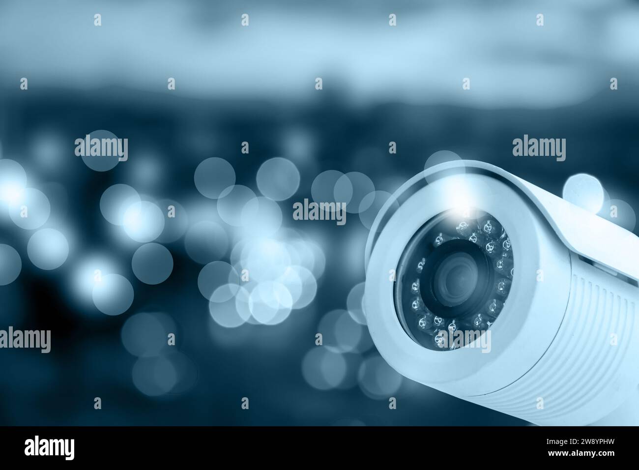 Modern security CCTV camera against blurred background, space for text ...