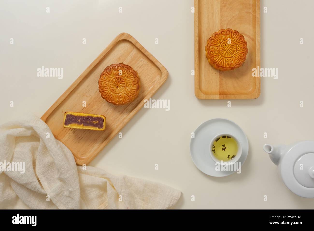 Top view of wooden trays of mooncakes decorated with tea set on white ...
