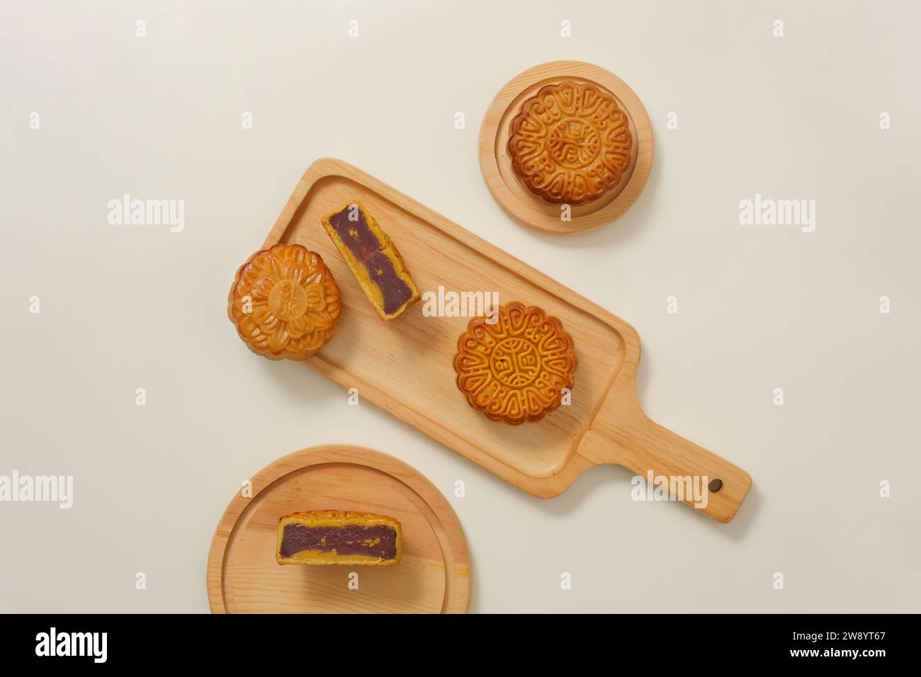 High view of appetizing mooncakes displayed on wooden trays on white ...