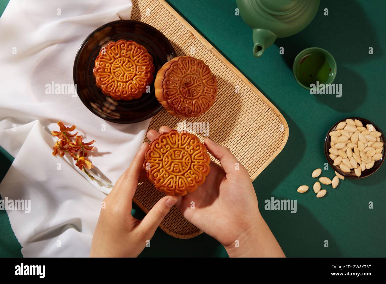 Hands of woman holding mooncakes on tea table background. Advertising ...