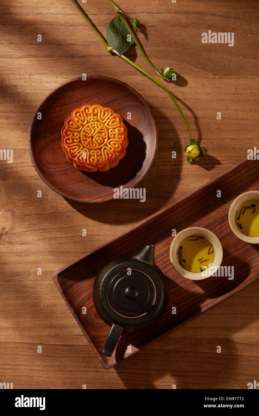A delicious mooncake on round dishes decorated with tea set on ...