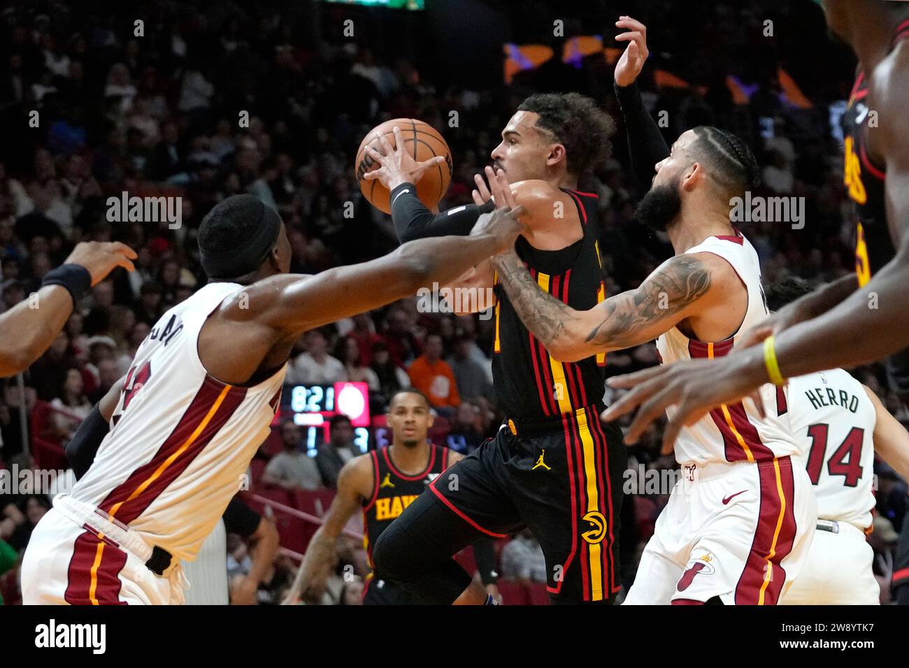 Atlanta Hawks guard Trae Young, center, drives to the basket as Miami Heat center Bam Adebayo ...