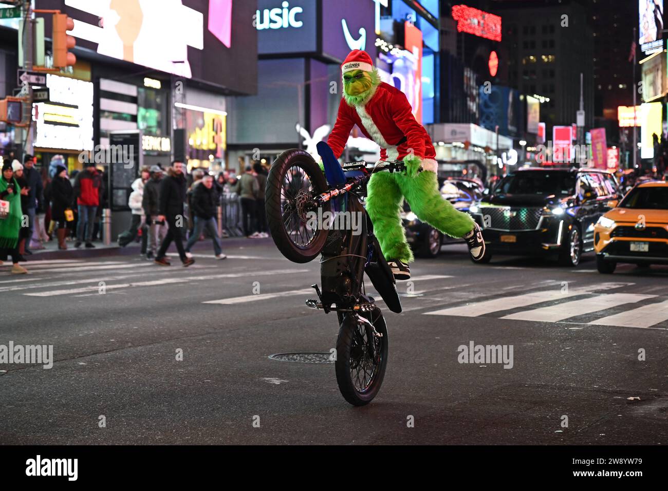 A cyclist dressed as the Grinch rides a bike through Times Square on ...