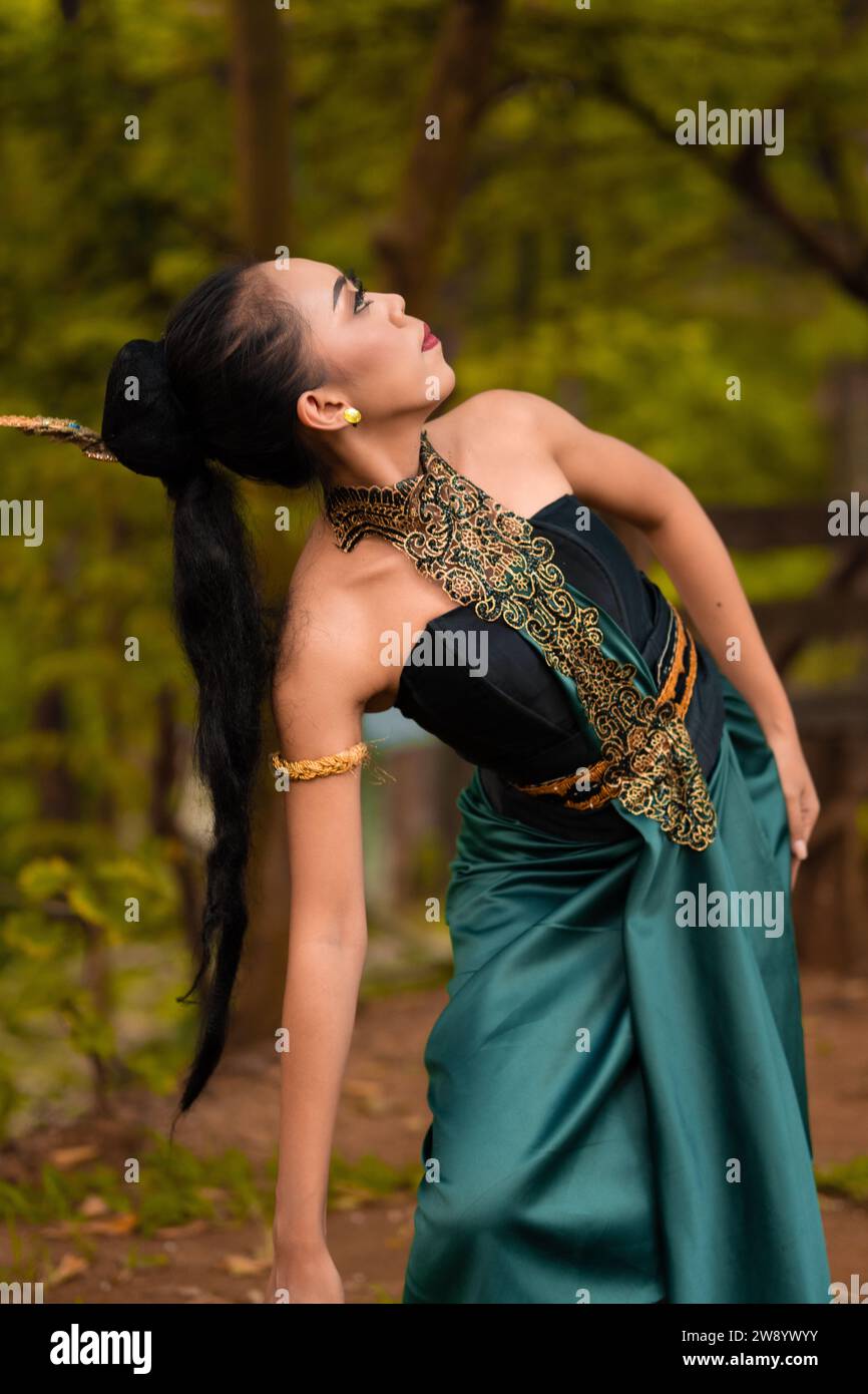 An Indonesian woman poses with black hair dangling to the ground while ...