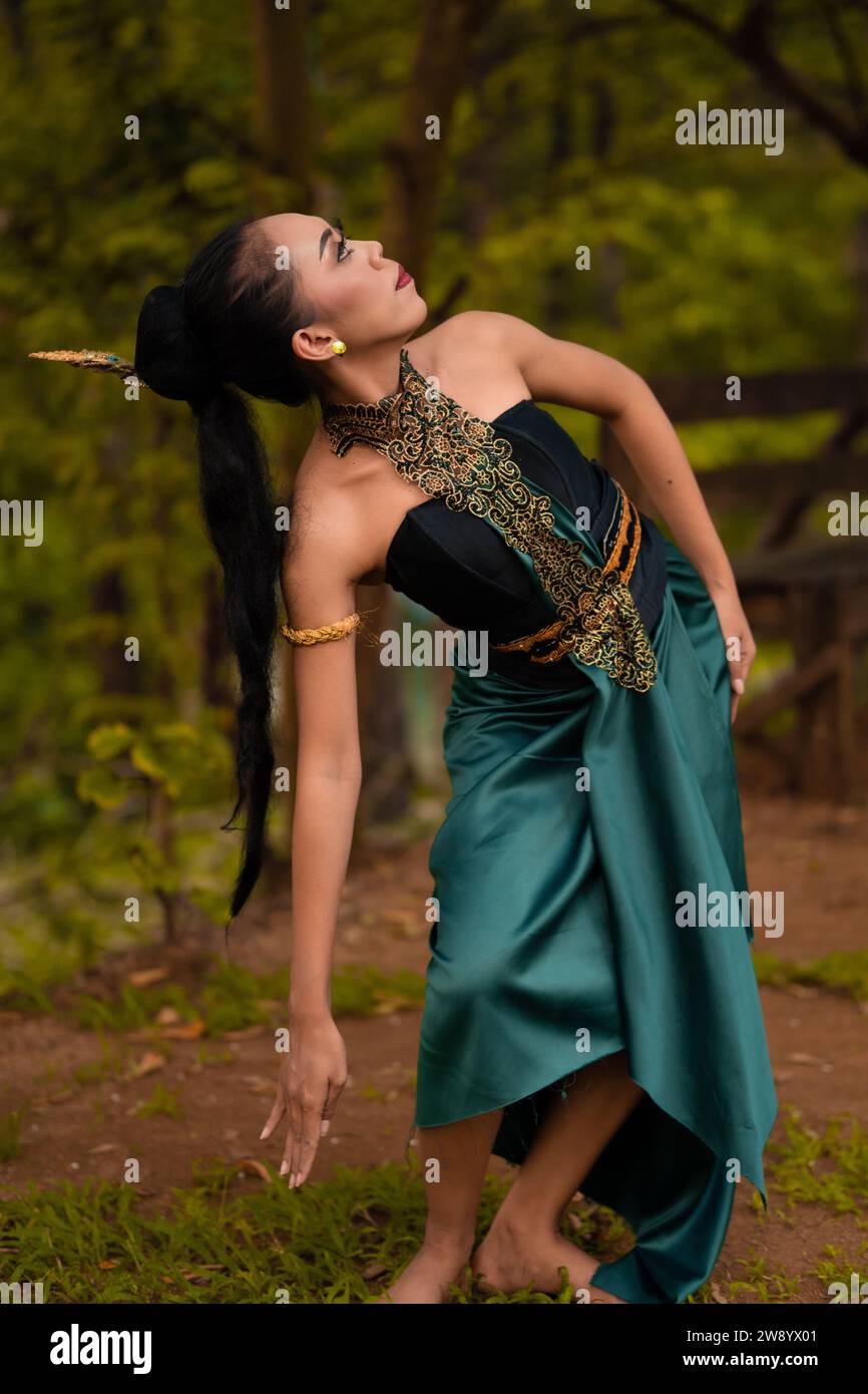 An Indonesian woman poses with black hair dangling to the ground while ...