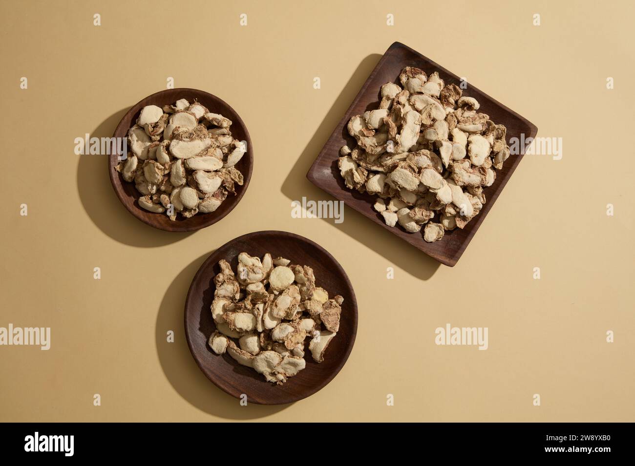 Top view of three wooden trays filled with sand ginger slices decorated ...