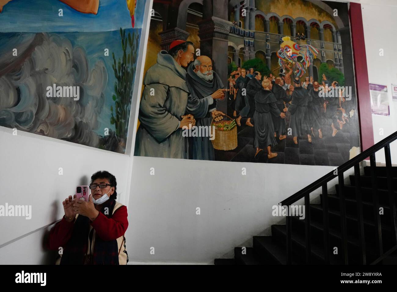 A tourist take a selfie with a painting showing Catholic missionaries ...