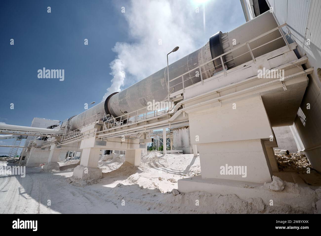 Long rotary furnace for limestone against smoking chimney Stock Photo ...