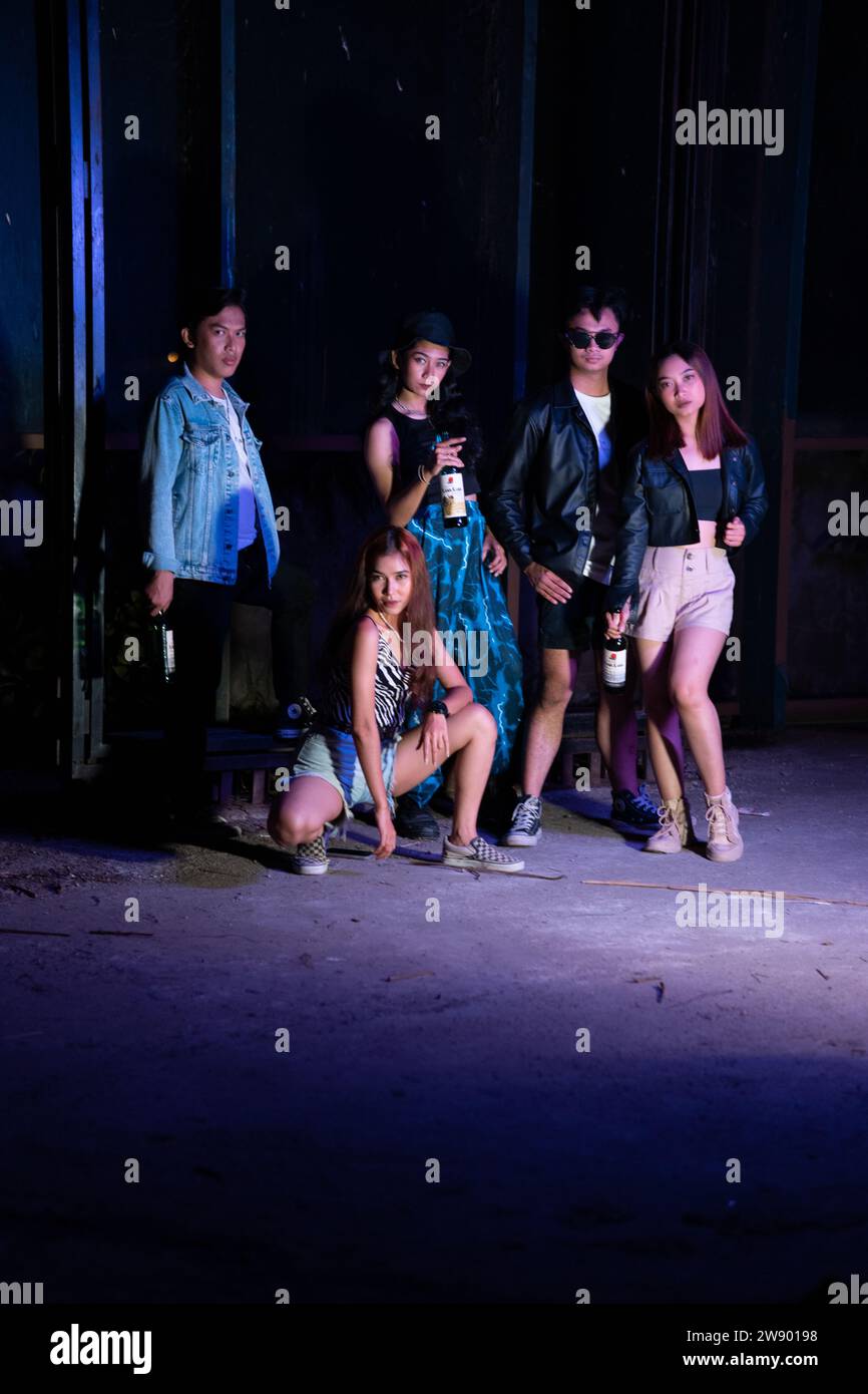 a group of teenagers taking a photo together with a purple light in ...