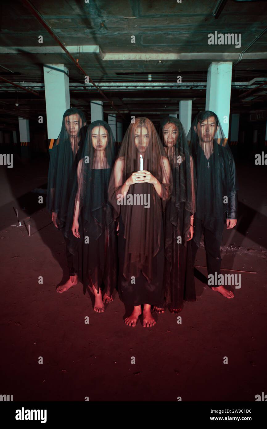 a group of devil worshipers in all black clothes and transparent veils ...