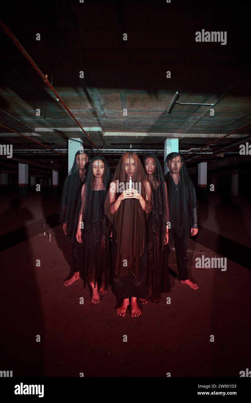 a group of devil worshipers in all black clothes and transparent veils ...